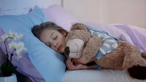 cute kid with teddy bear sleeping in bed | Stock Video | Pond5