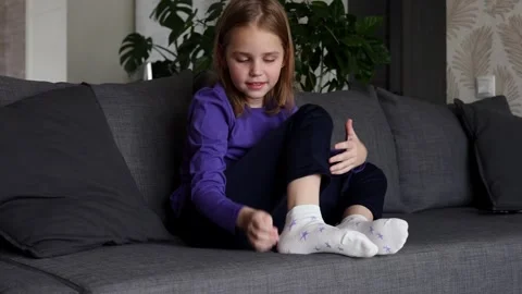 A cute little blonde girl puts white soc... | Stock Video | Pond5