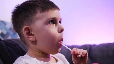 A cute little boy eating candy on the so... | Stock Video | Pond5