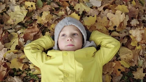 Cute little boy laying on ground covered... | Stock Video | Pond5