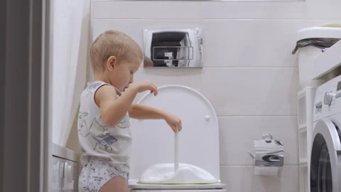 Cute little boy learning to use the toil... | Stock Video | Pond5