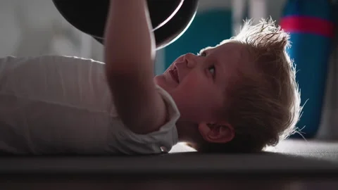 Cute little boy tries to lift heavy barb... | Stock Video | Pond5