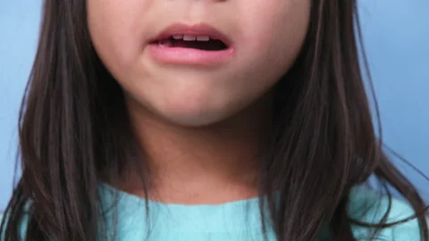 Cute little girl chewing gum on blue bac... | Stock Video | Pond5