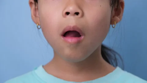 Cute little girl chewing gum on blue bac... | Stock Video | Pond5