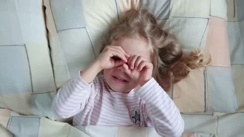 Cute little girl just awakening, laying ... | Stock Video | Pond5