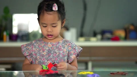 Cute little girl learn to use scissor at... | Stock Video | Pond5