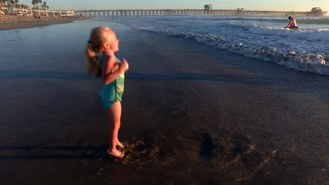 Cute Little Girl Playing in Ocean Waves | Stock Video | Pond5