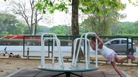 Cute little girl playing roundabout at p... | Stock Video | Pond5