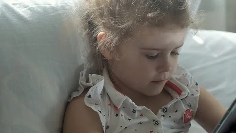 cute little girl is sitting on the bed ... | Stock Video | Pond5