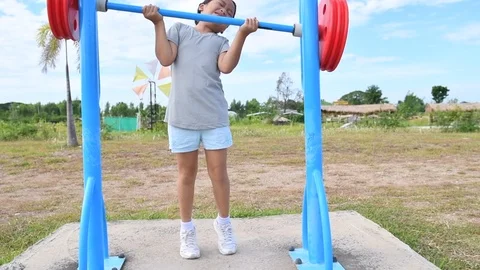 cute little girl trying to lift weight, | Stock Video | Pond5