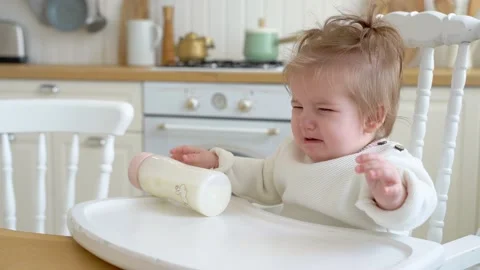 Cute messy baby girl crying while drinks... | Stock Video | Pond5