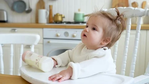 Cute messy baby girl crying while drinks... | Stock Video | Pond5