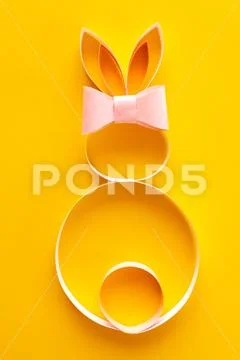 Cute paper bunny with bow on yellow background Stock Image #106563741
