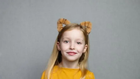 Cute smiling blond girl with tiger ears.... | Stock Video | Pond5