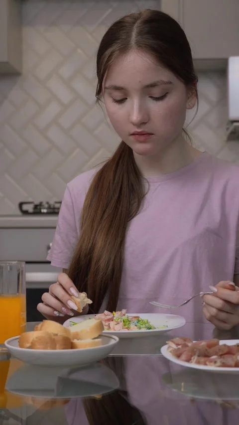 Cute teen girl eating breakfast eating j... | Stock Video | Pond5