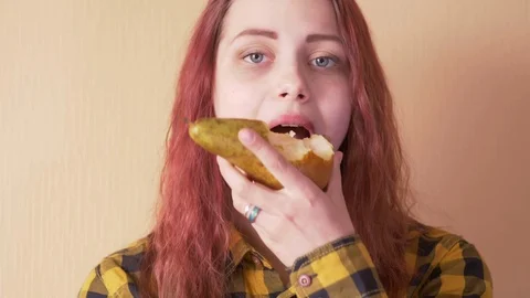 Cute teen girl eating pear | Stock Video | Pond5