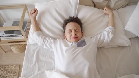 Cute teenager boy waking up in morning. ... | Stock Video | Pond5