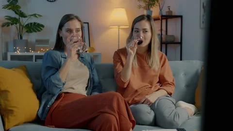 Cute young women watching TV pointing at... | Stock Video | Pond5