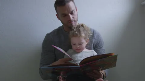 Dad and Daughter Sit On Floor Reading Bo... | Stock Video | Pond5