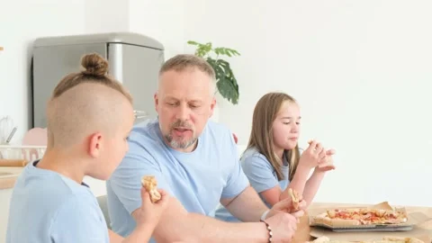 Dad with children eating pizza at home s... | Stock Video | Pond5