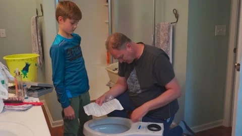 Dad going over toilet replacement in bat... | Stock Video | Pond5