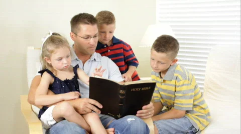 dad reading bible to kids | Stock Video | Pond5