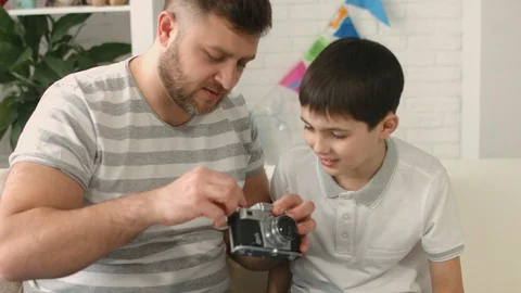 Dad shows his son a camera device | Stock Video | Pond5
