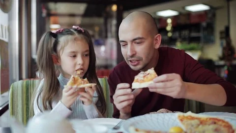 Dad with a small daughter eat pizza at a... | Stock Video | Pond5