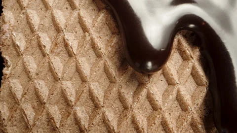 Dark chocolate is flowing down a waffle,... | Stock Video | Pond5