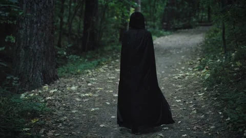 A dark figure in a black cloak with a ho... | Stock Video | Pond5