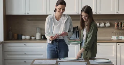 Daughter helps mom to set table for dini... | Stock Video | Pond5
