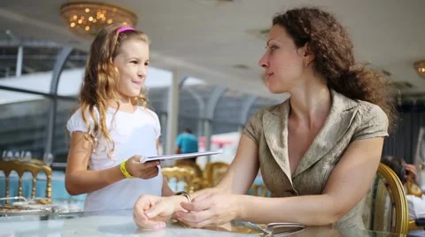 Daughter waiter takes menu for mother in... | Stock Video | Pond5