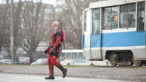Deadpool cosplayer is crossing city stre... | Stock Video | Pond5