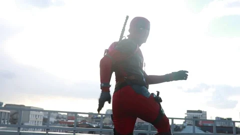 Deadpool cosplayer posing with guns and ... | Stock Video | Pond5