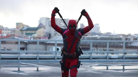 Deadpool cosplayer runs with guns and ka... | Stock Video | Pond5