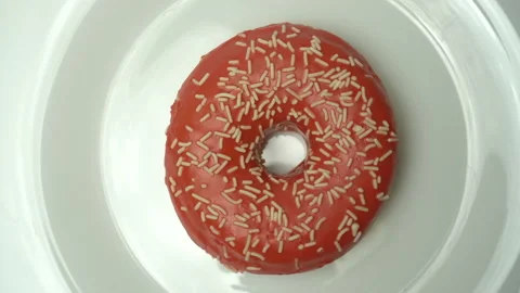 Delicious sweet red donut rotating on a ... | Stock Video | Pond5