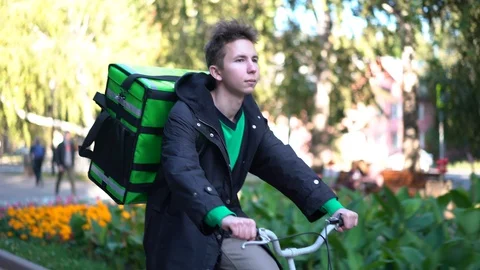 delivery man with green bagpack rides a ... | Stock Video | Pond5