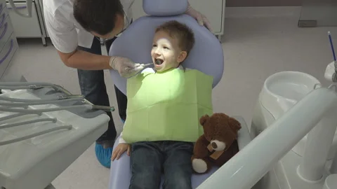Dentist checks little boy sitting near h... | Stock Video | Pond5