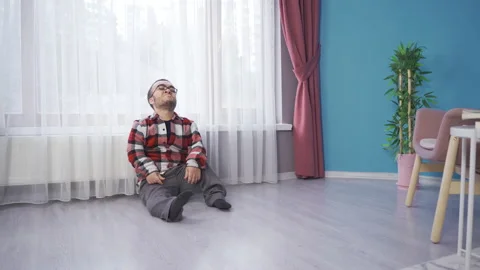 Depressed dwarf man sitting on the floor... | Stock Video | Pond5