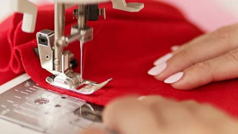Designer sews red fabrics on a sewing ma... | Stock Video | Pond5