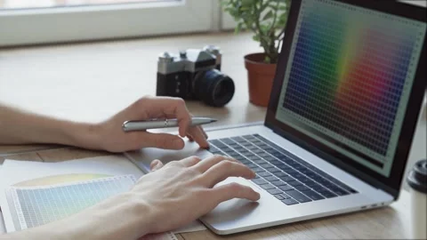 designer works on a laptop with a color ... | Stock Video | Pond5