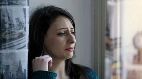 desperate woman crying at the window | Stock Video | Pond5