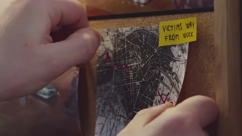The detective's hand pins the map to the... | Stock Video | Pond5