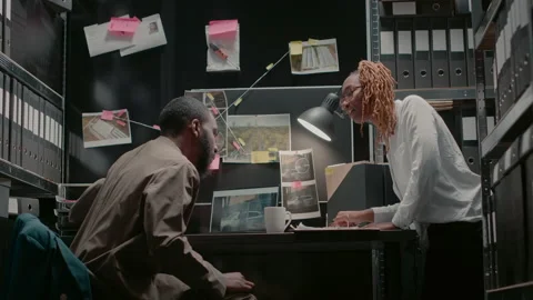 Detectives team looking at evidence boar... | Stock Video | Pond5
