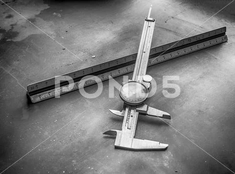 Dial caliper and ruler on a machine shop steel bench Stock Photo #97398460