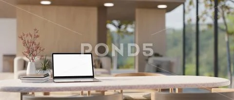 A dining table with a white-screen laptop mockup in a modern, luxury ...