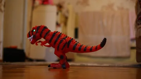Dinosaur toy red dinosaur makes sounds. | Stock Video | Pond5