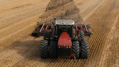 Disking the field. Big red Tractor culti... | Stock Video | Pond5