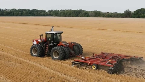 Disking the field. Big red Tractor culti... | Stock Video | Pond5