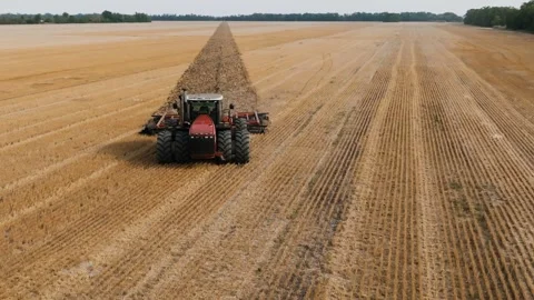 Disking the field. Big red Tractor culti... | Stock Video | Pond5